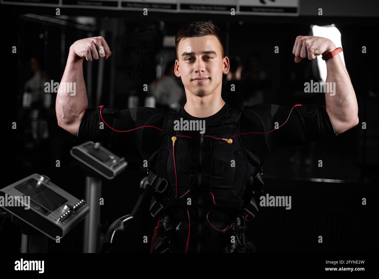 Muscular man trainer weared ems electrical body suit in gym. electro ...
