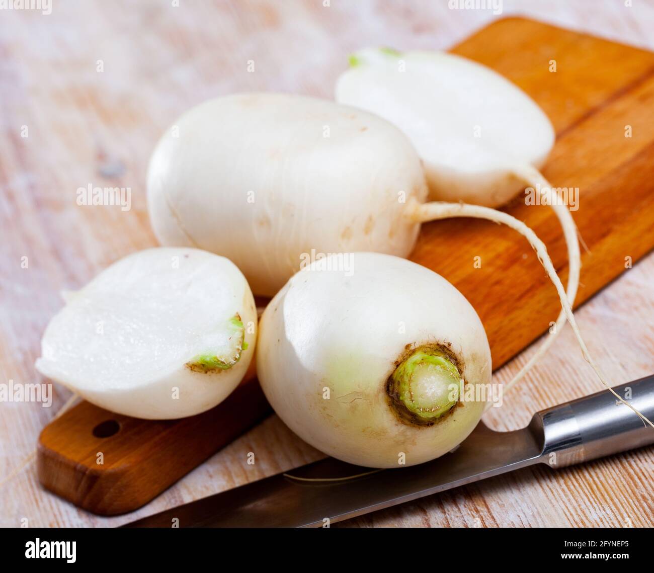 Whole and cut in half ripe turnips root crops on wooden background ...