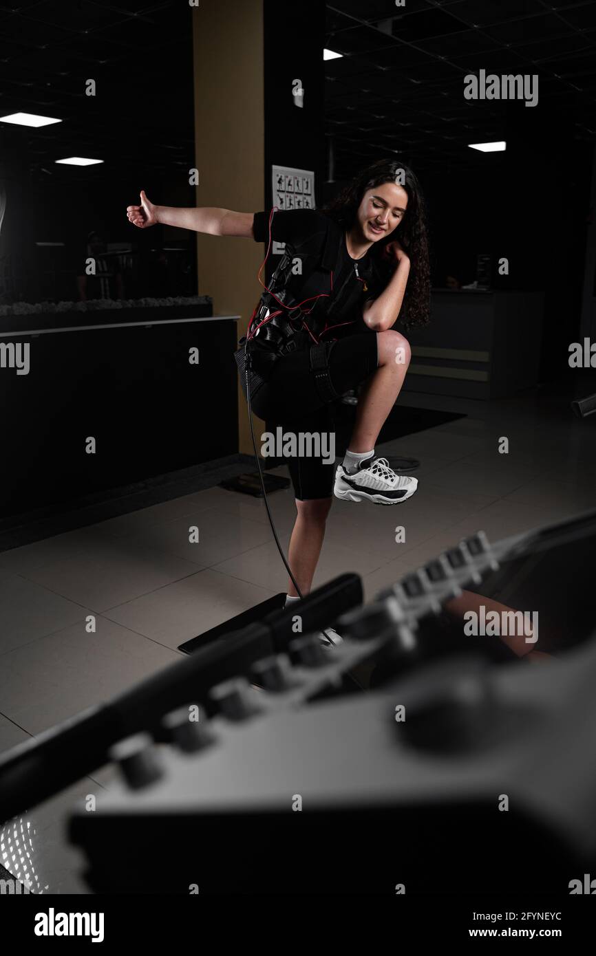 Making physical exercises using EMS suit in gym. Sport training in ...