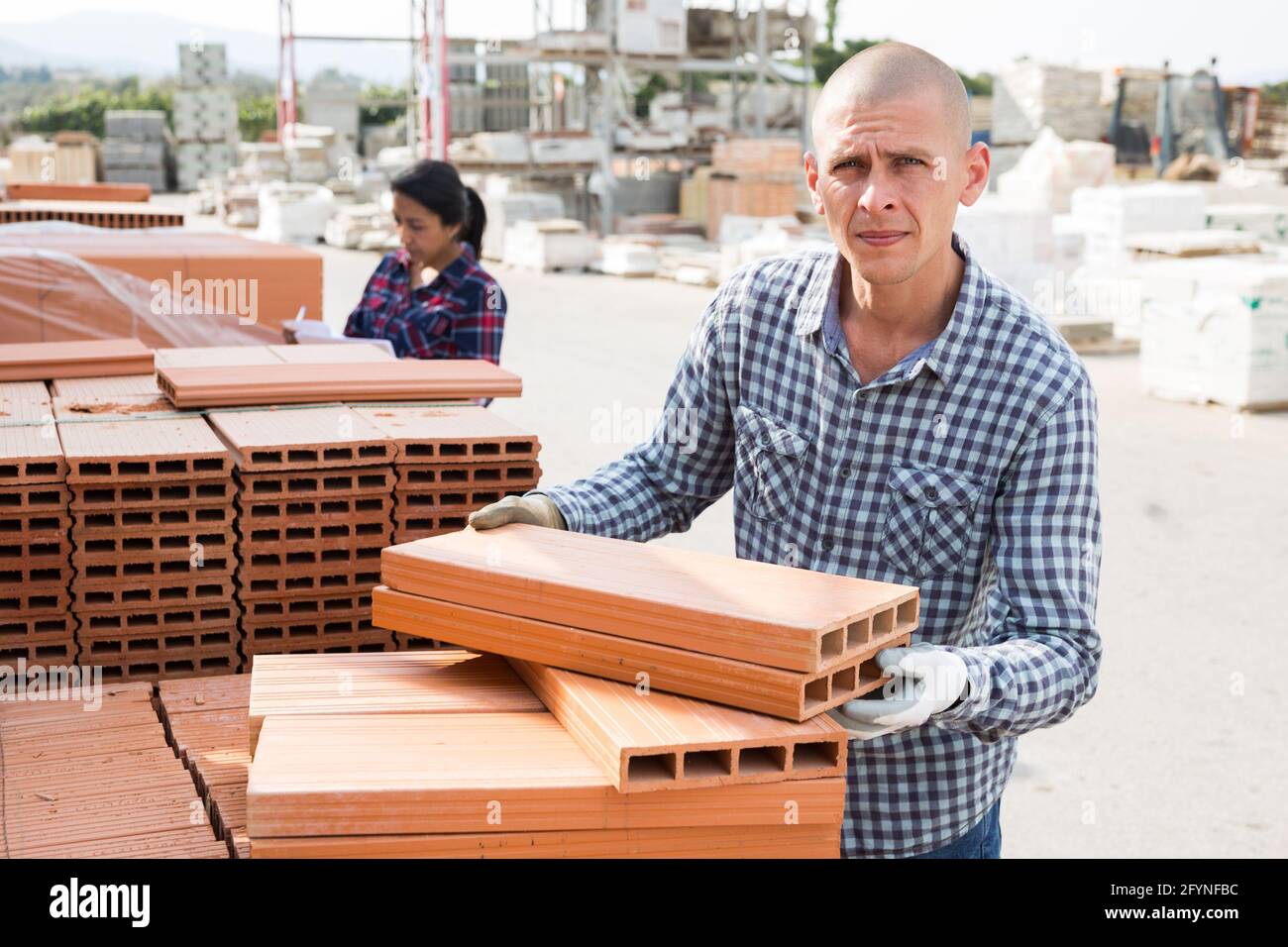 Positive handyman working with insulation panels at warehouse of ...