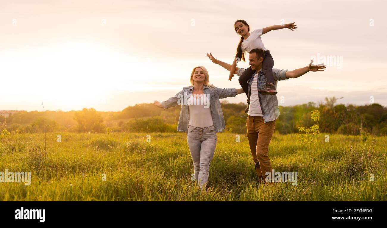 Happy family in the park evening light. The lights of a sun. Mom, dad ...