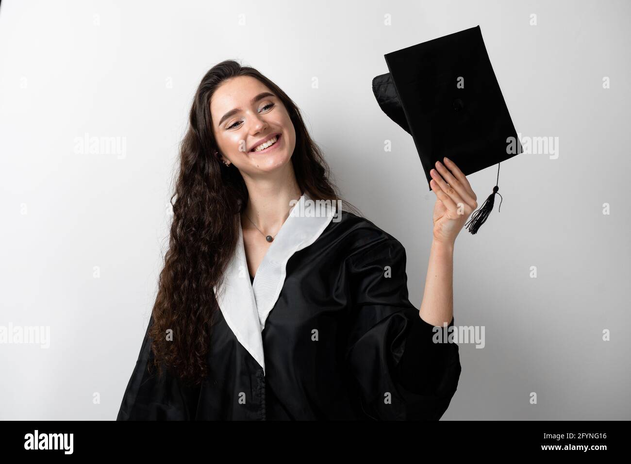 Graduate girl with master degree in black graduation gown and cap on ...