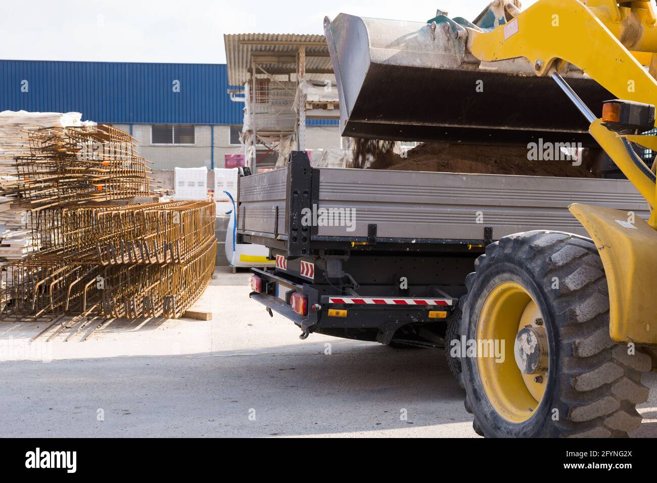 Front loader loads sand into the back of a truck Stock Photo - Alamy