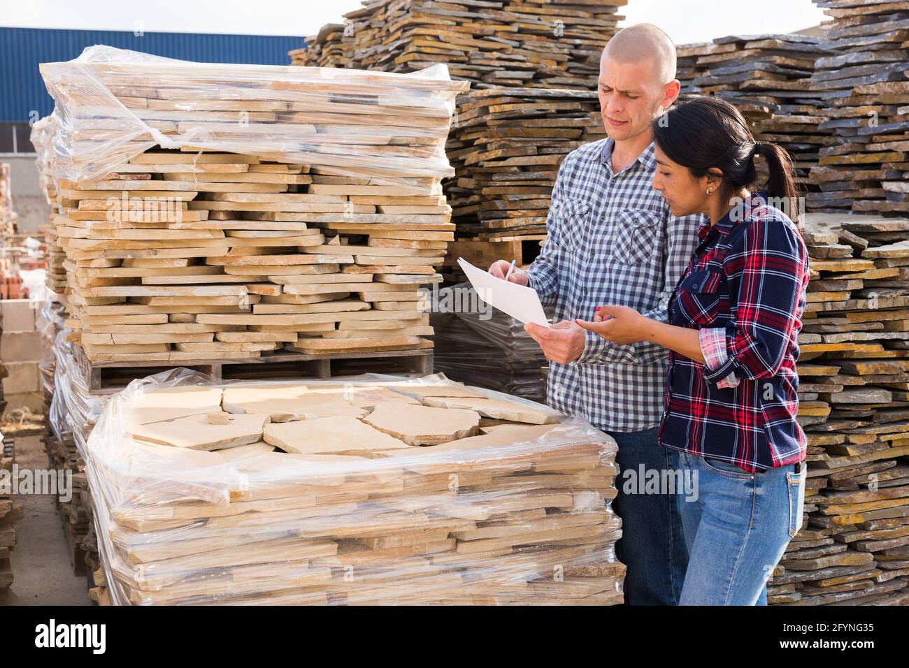 Confident woman shopper discussing with man quality of natural stone ...
