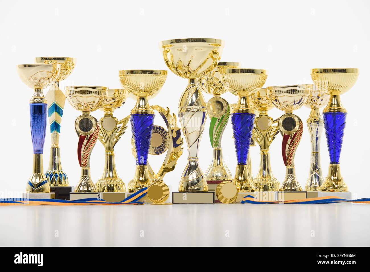 Gold prize cups and medals for winner of sport competition on white ...