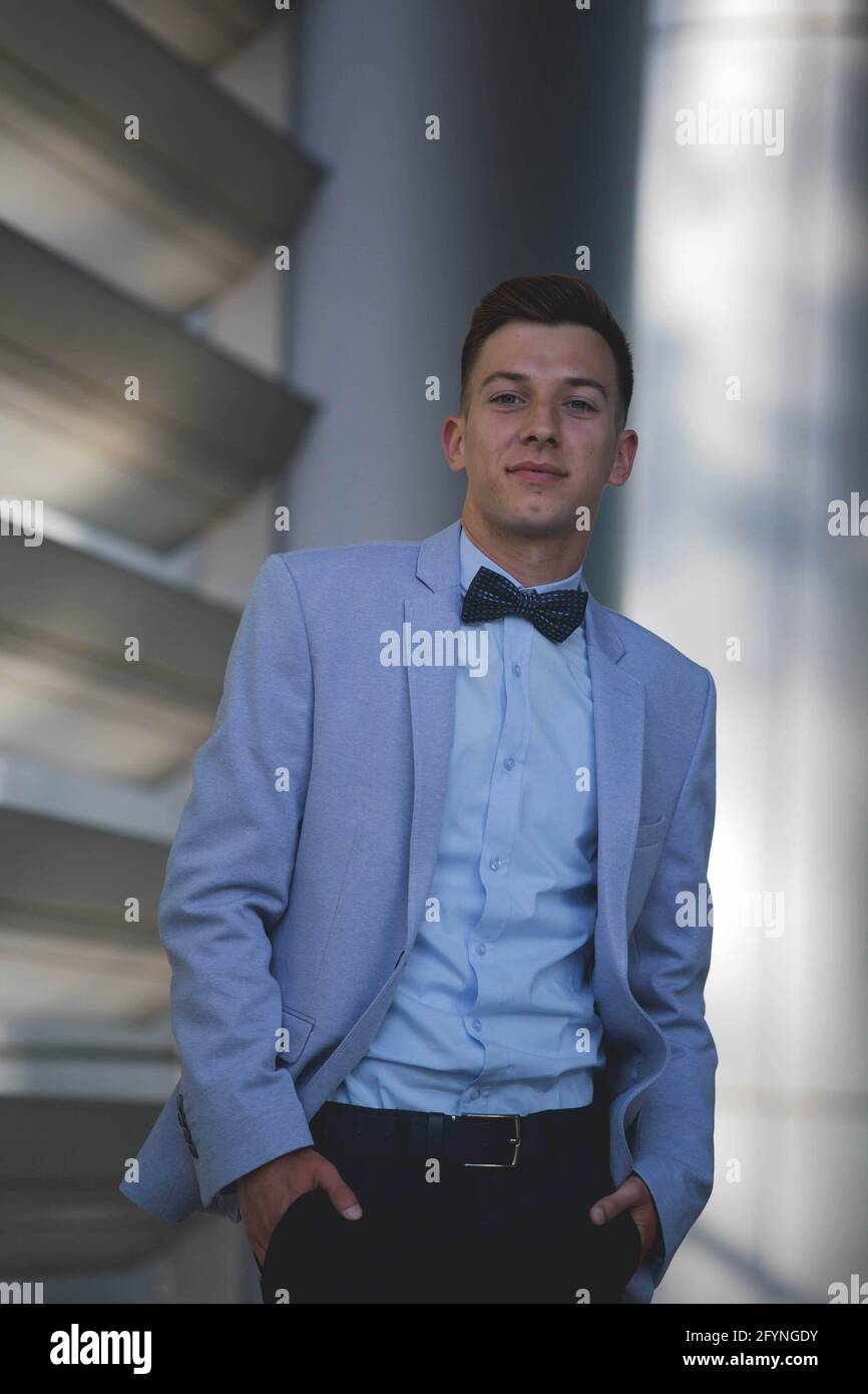 Vertical shot of a handsome Bosnian Caucasian man in a suit and bow tie ...