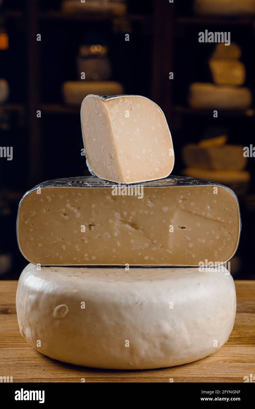 Goat cheese wheel and big pieces of it. Mix of cheeses from goat milk ...