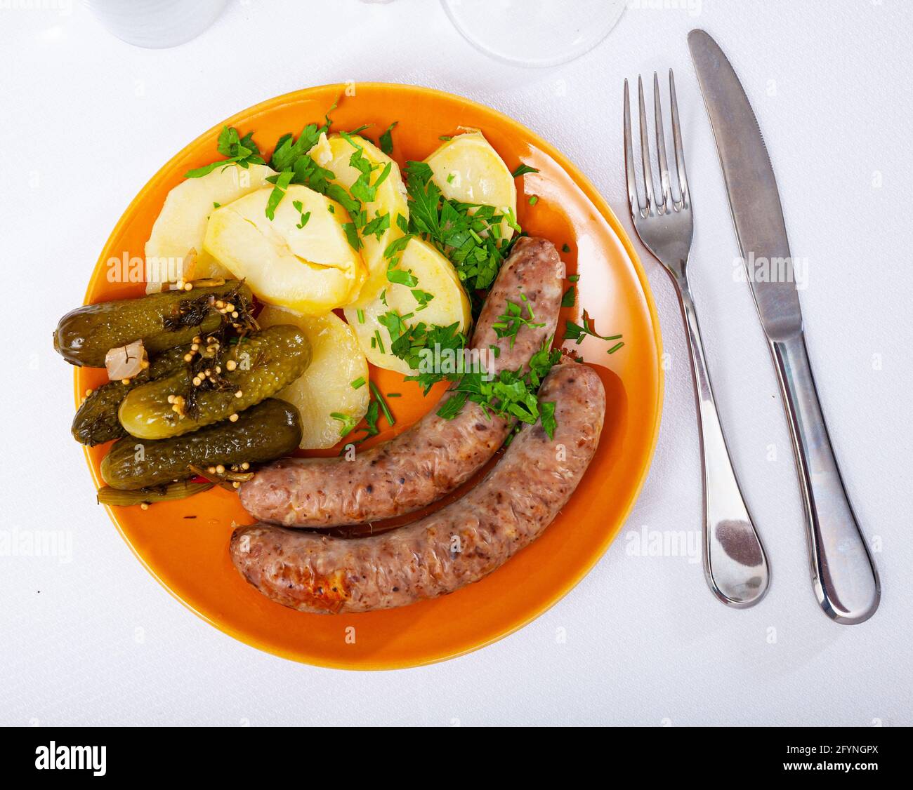 Eastern european cuisine - sausages with potatoes and pickled cucumbers ...