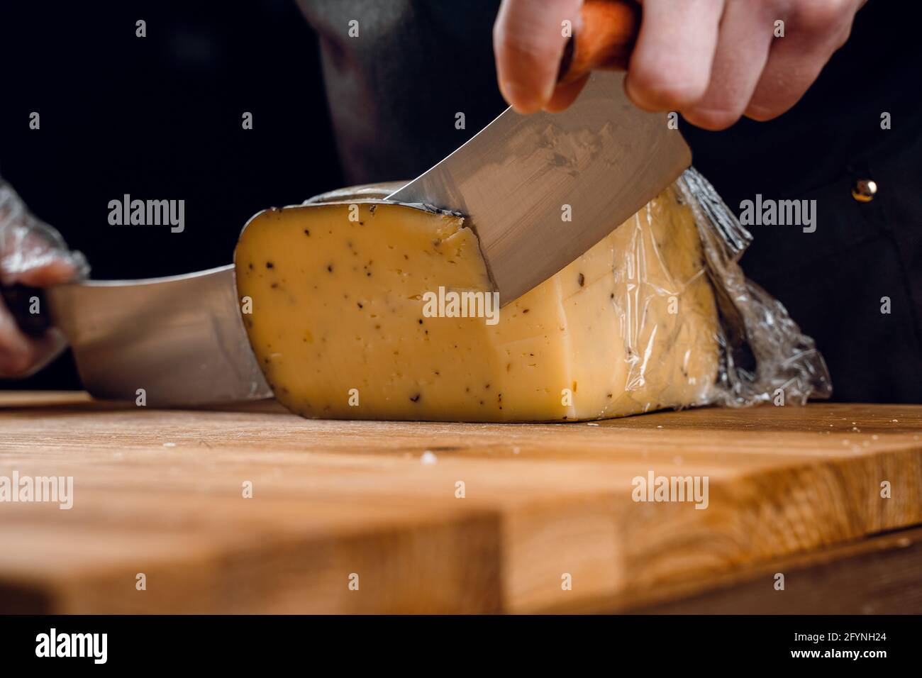 Slicing aged cheese parmesan with crystals using slicer knife. Hard ...