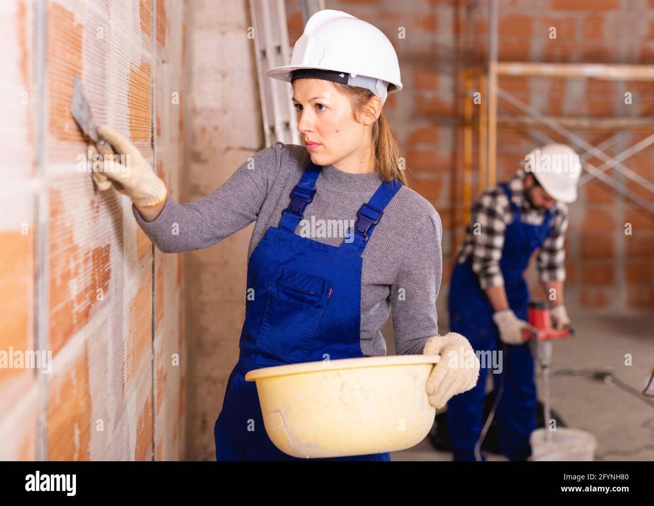 Portrait of two builders in process of finishing work in cottage Stock ...
