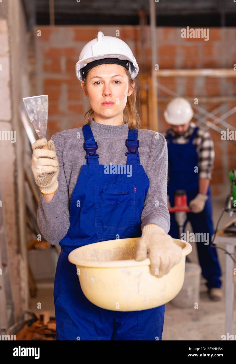 Portrait of two builders in process of finishing work in cottage Stock ...