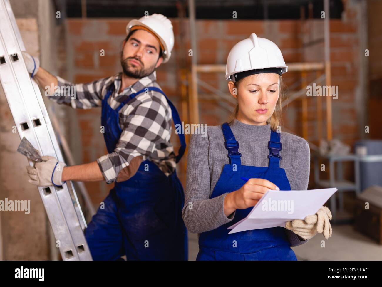 Female foreman checking the work of the builders in house Stock Photo ...