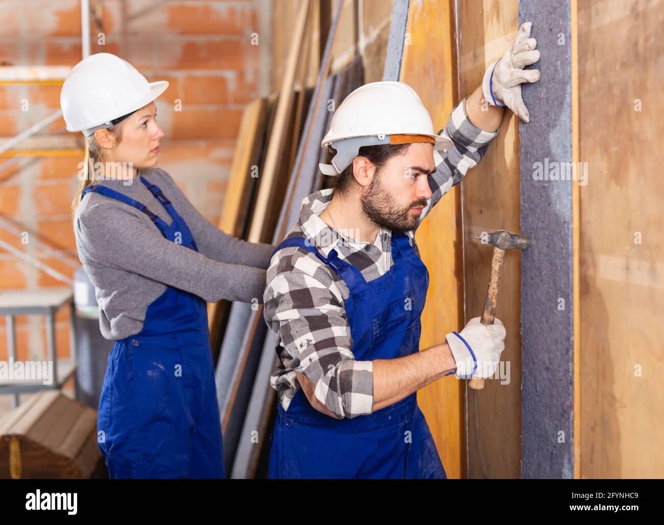 Two professional builders sheathe walls with insulation Stock Photo - Alamy