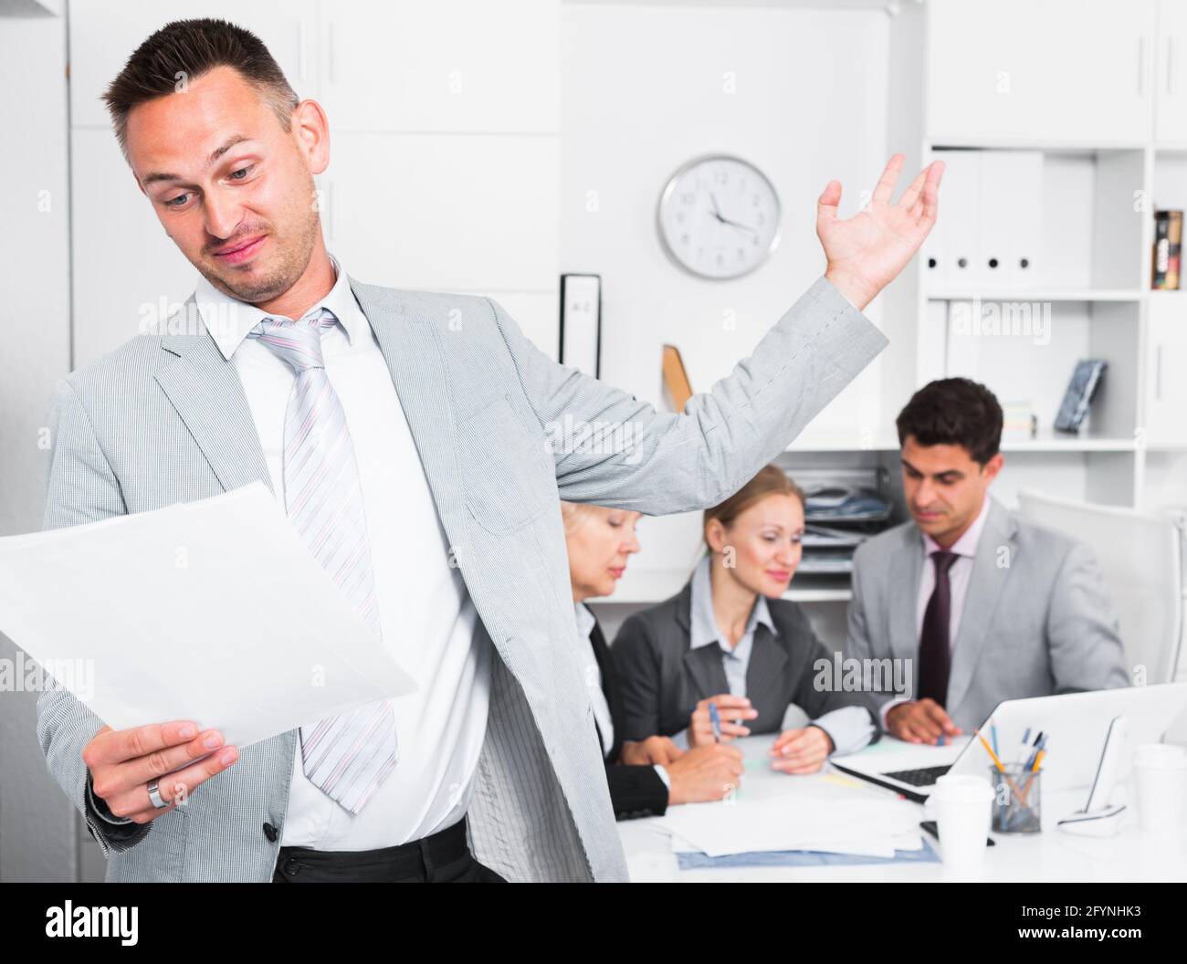 Businessman standing apart feeling angry to coworkers in office Stock ...