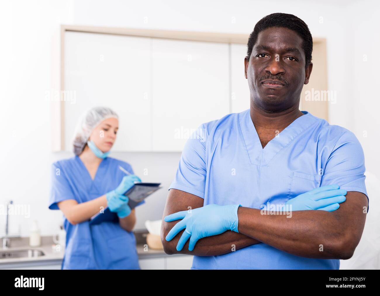 Portrait of confident african american male cosmetologist standing in ...