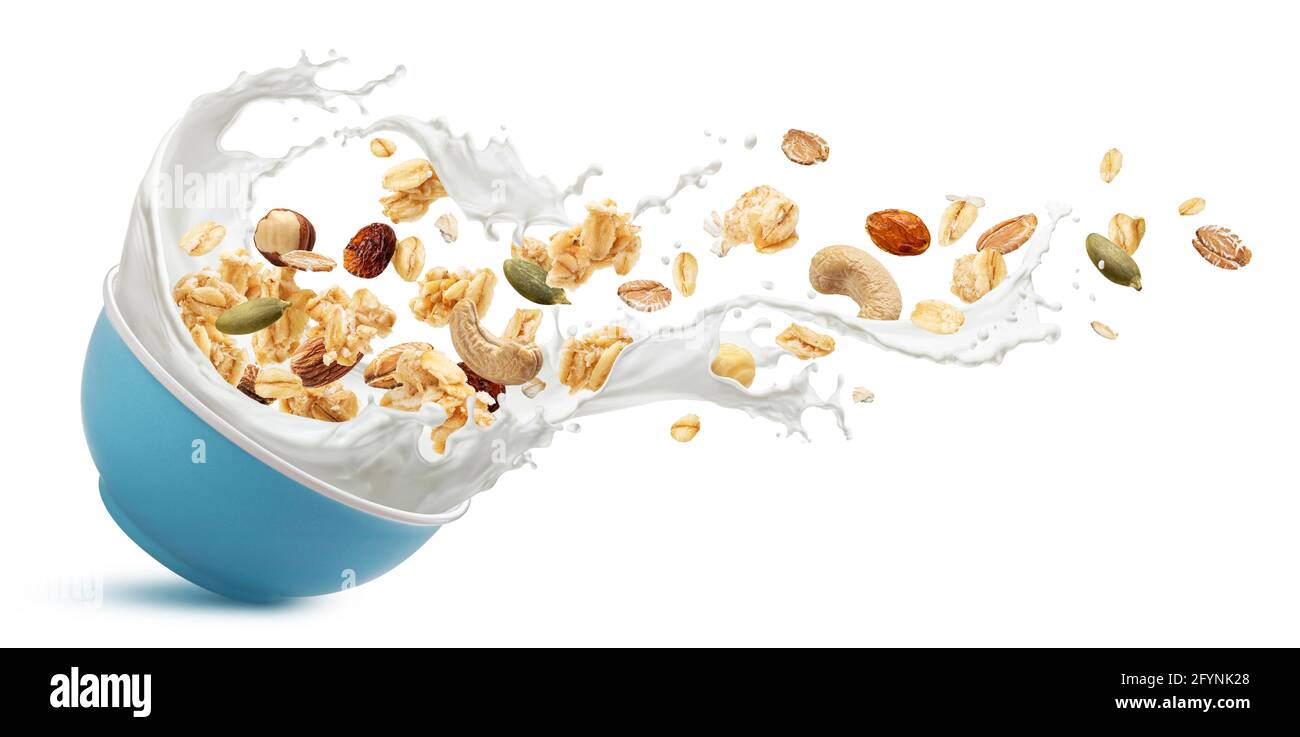 Falling crunchy muesli, bowl of oat granola with milk splashing ...