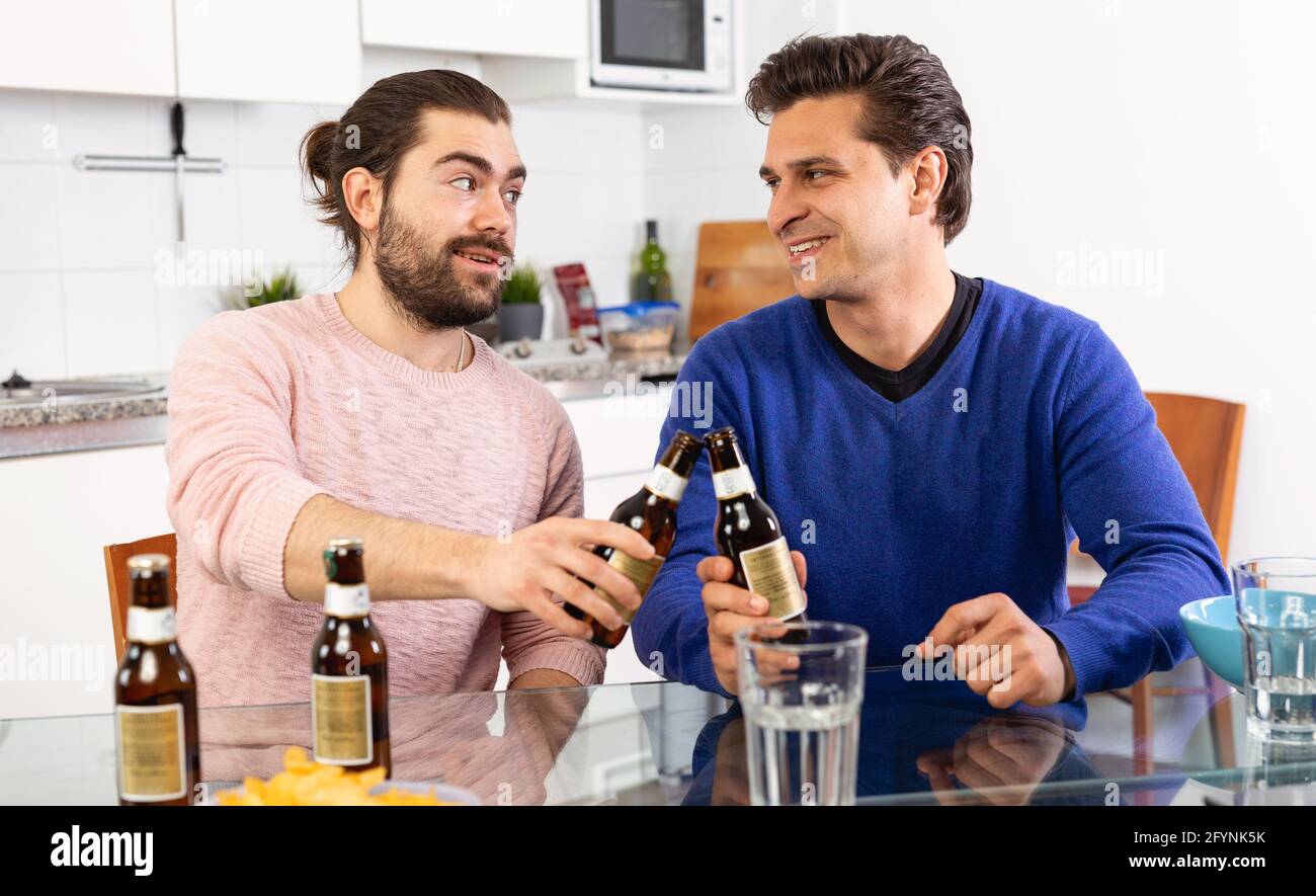 Two friends with bottles of beer celebrate happy event Stock Photo - Alamy