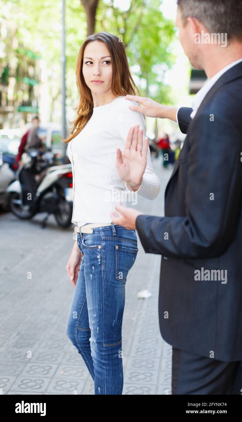 Young woman stopping stranger man bothering her on city street Stock ...