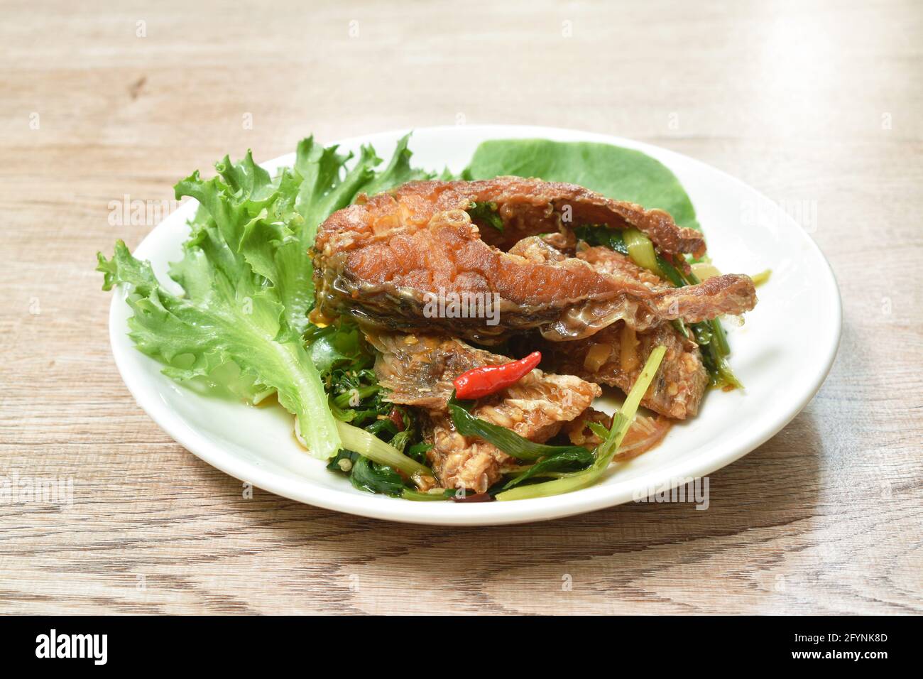 deep fried slice striped snake head fish with ginger and celery on dish ...
