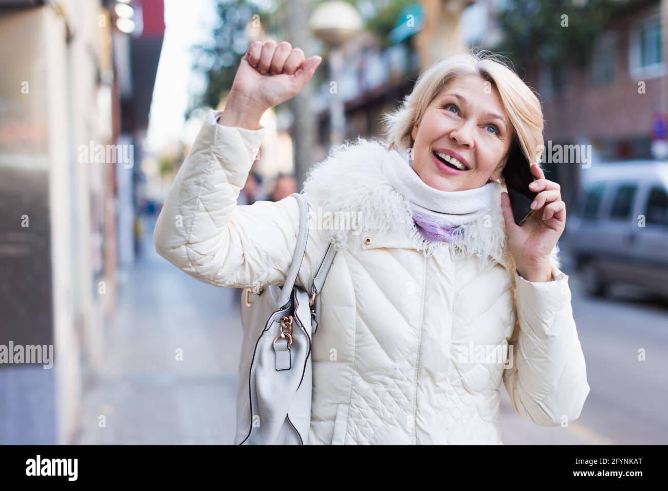 Happy female raise hand up and talking on phone outdoor Stock Photo - Alamy