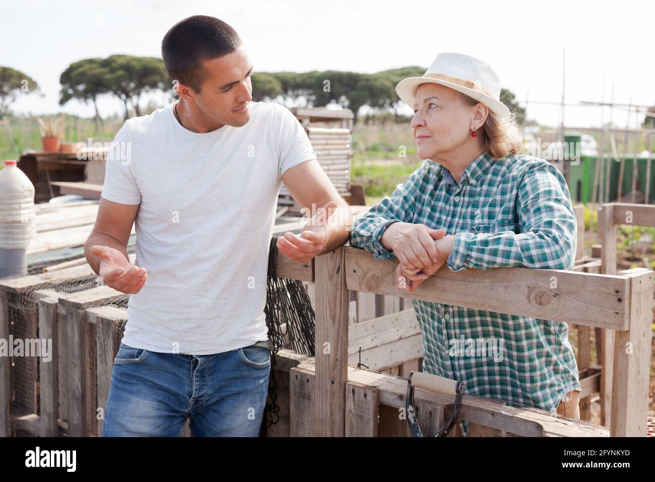 Farm neighbors talk at the border Stock Photo - Alamy