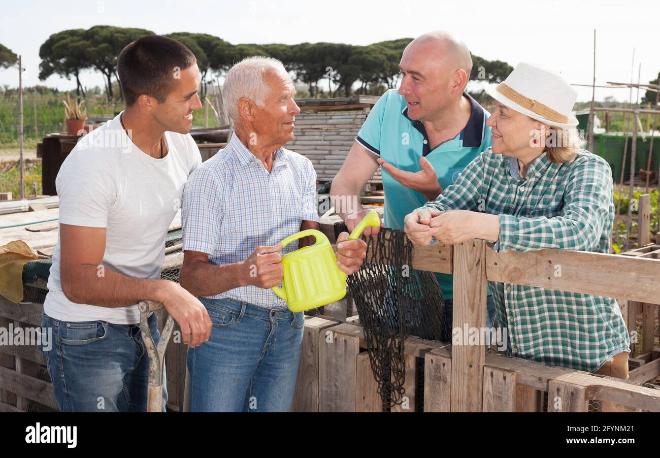Farm neighbors talk at the border of the garden plot Stock Photo - Alamy