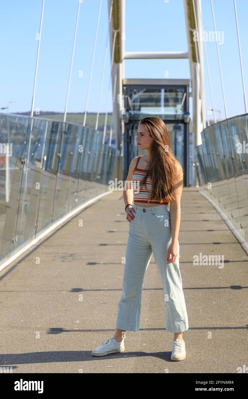 Shallow focus of a young brunette woman wearing jeans with a crop top ...