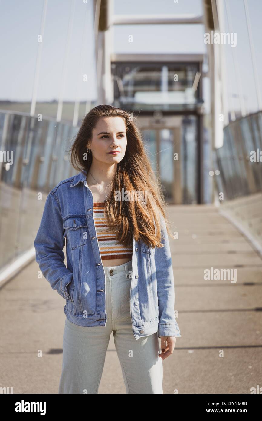 Shallow focus of a young brunette woman wearing jeans with a crop top ...