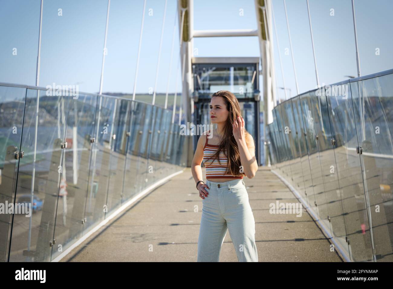 Shallow focus of a young brunette woman wearing jeans with a crop top ...