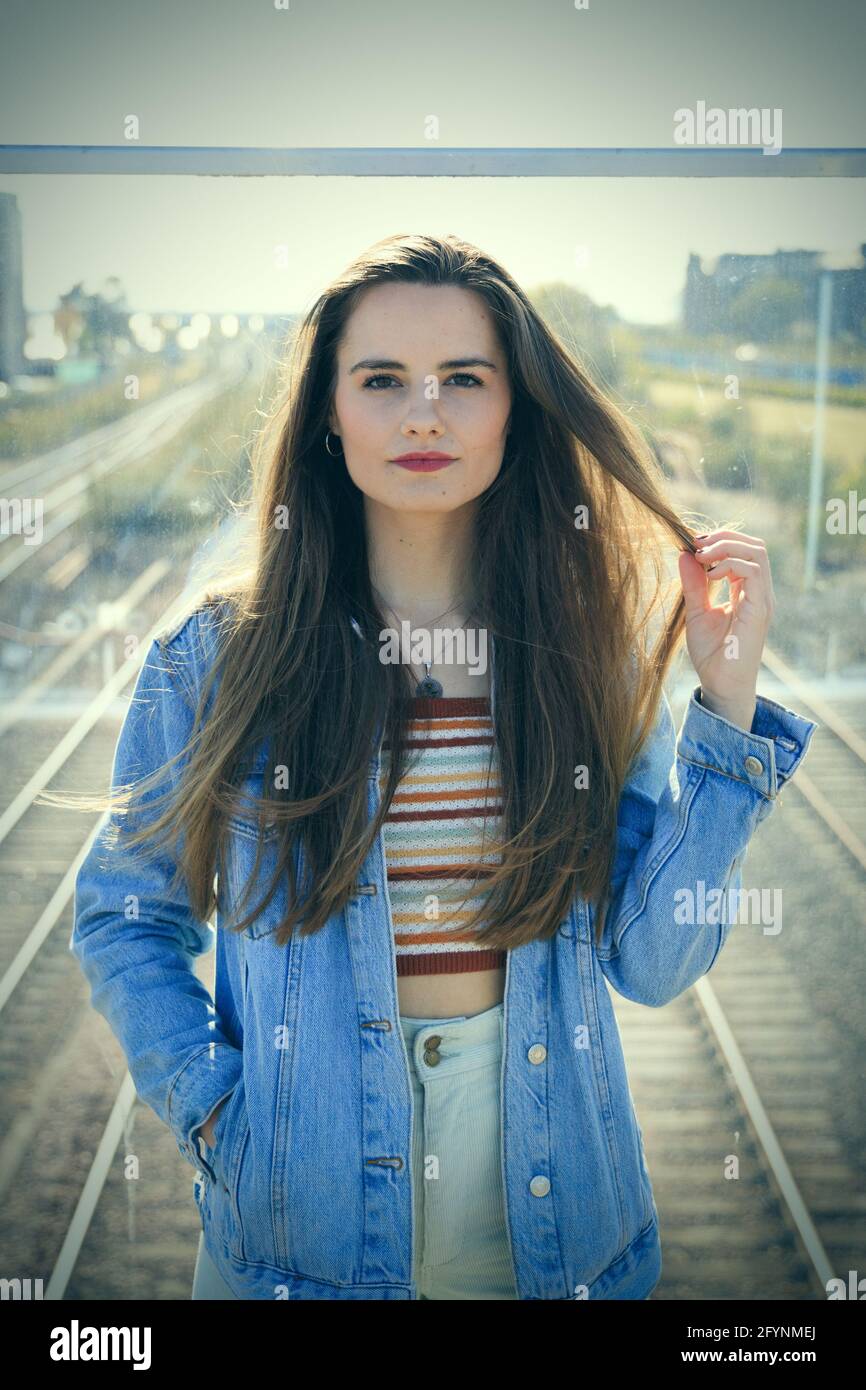 A shallow focus of a young Caucasian brunette woman wearing a denim ...