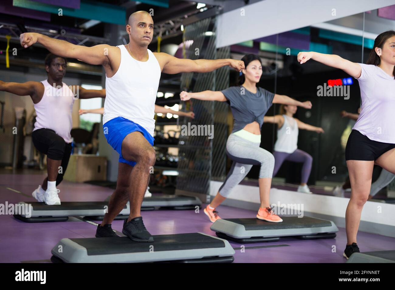 Athletic people performing step aerobics in fitness club Stock Photo ...