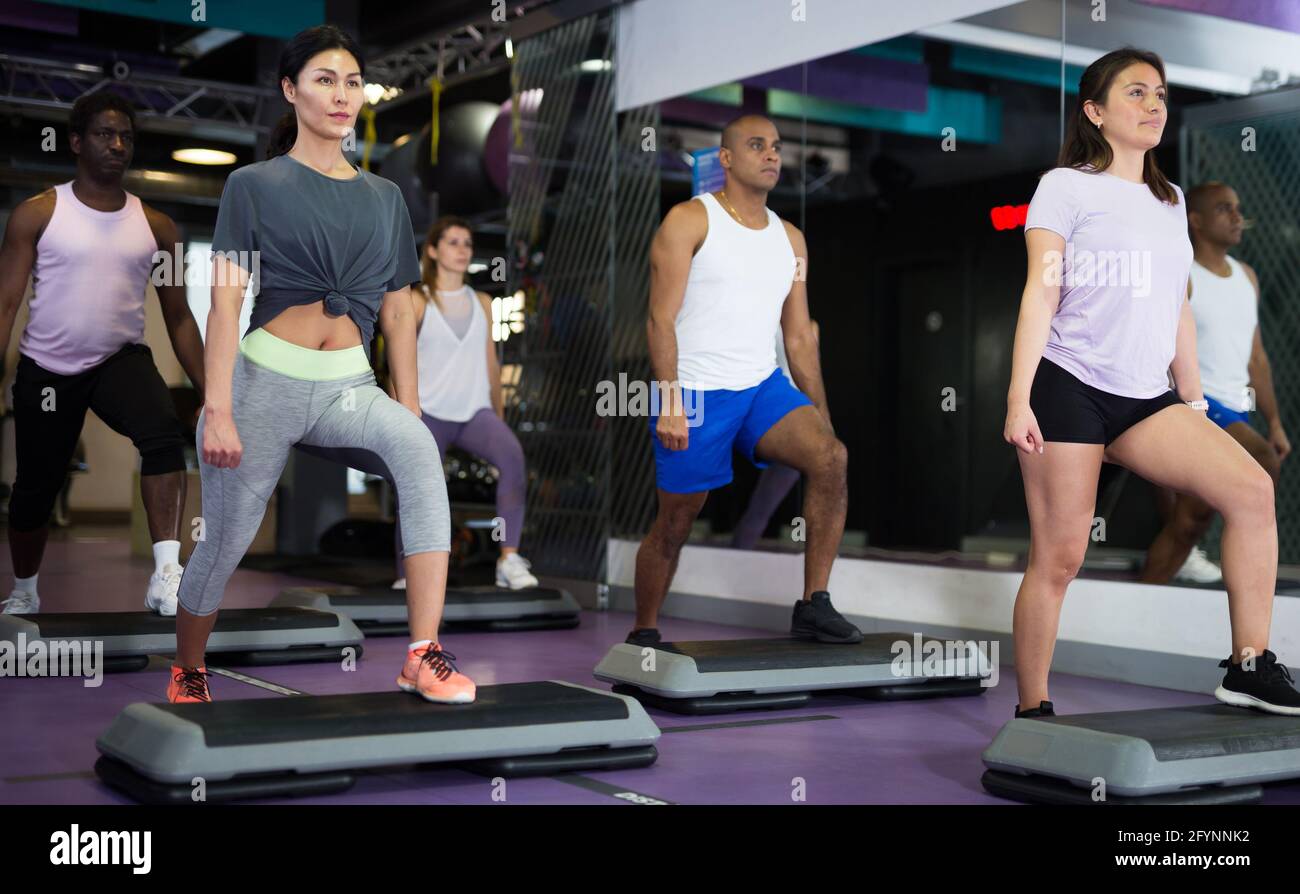 Athletic people performing step aerobics in fitness club Stock Photo ...