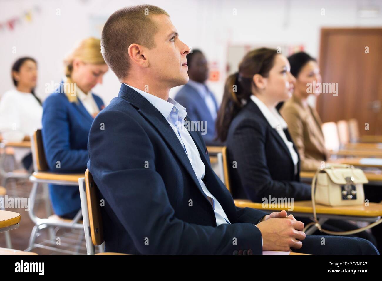 Portrait of focused businessman attending business conference ...