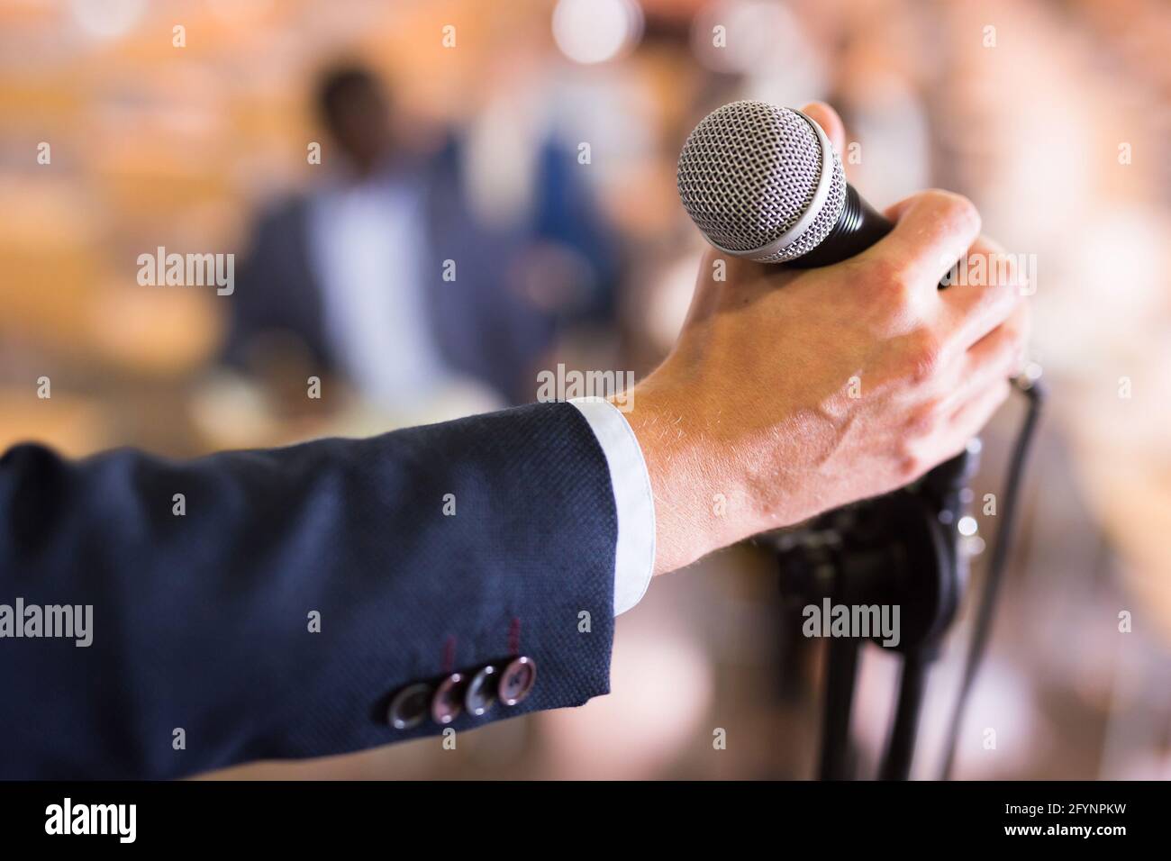 Close up of male hand holding microphone at conference hall Stock Photo ...