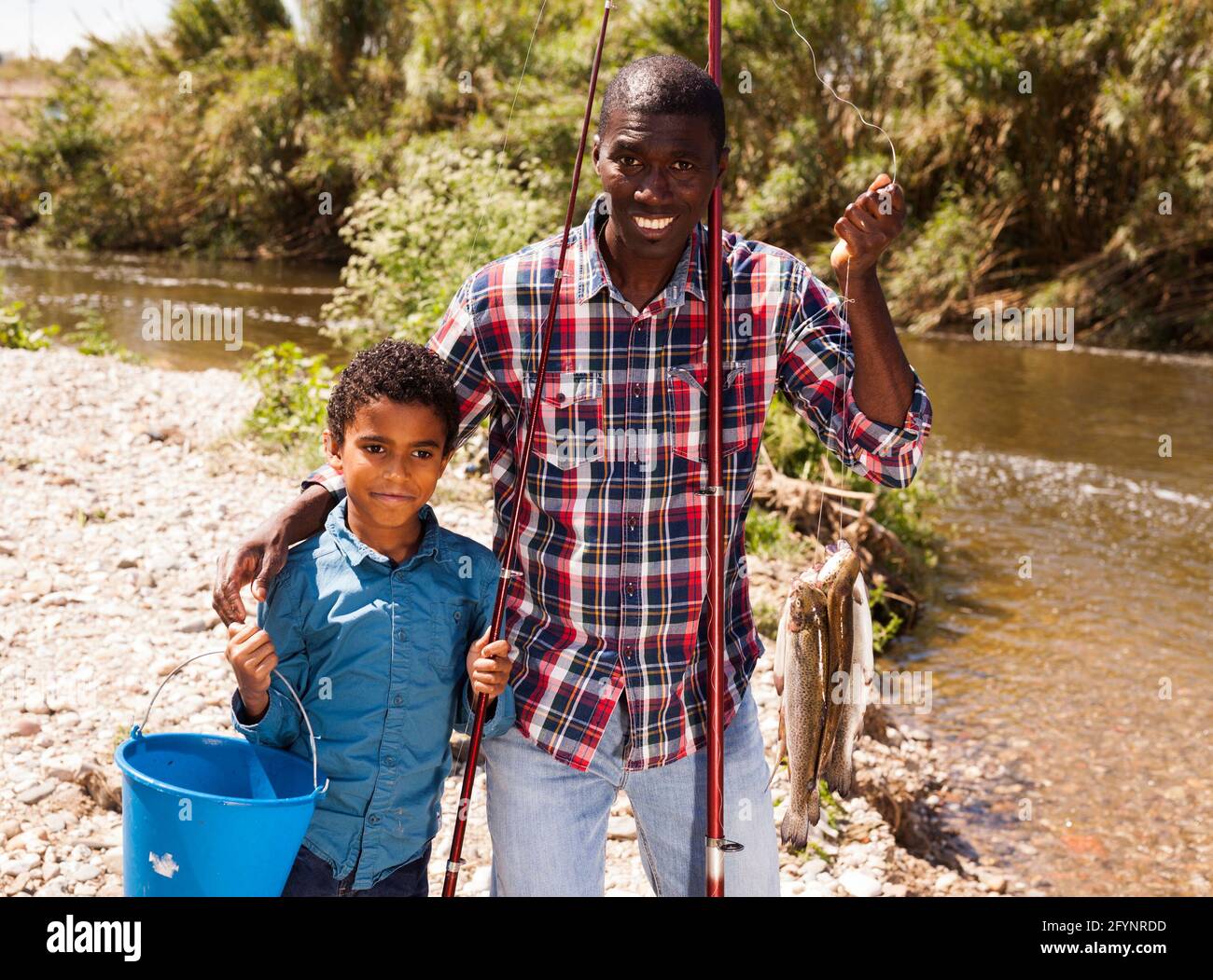 Portrait of fishermen - African man and his little son posing with ...