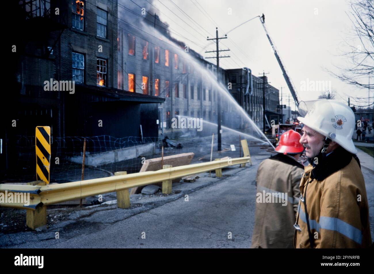live fire and fire engine with firemen and fire trucks with hoses ...