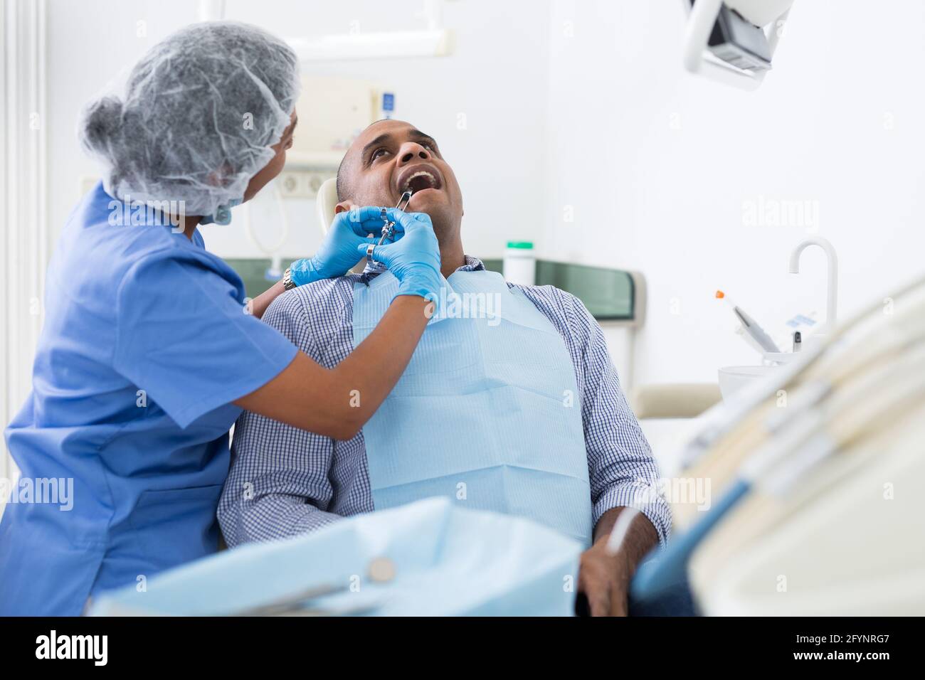 Dentist operates on patient - removes a bad tooth Stock Photo - Alamy