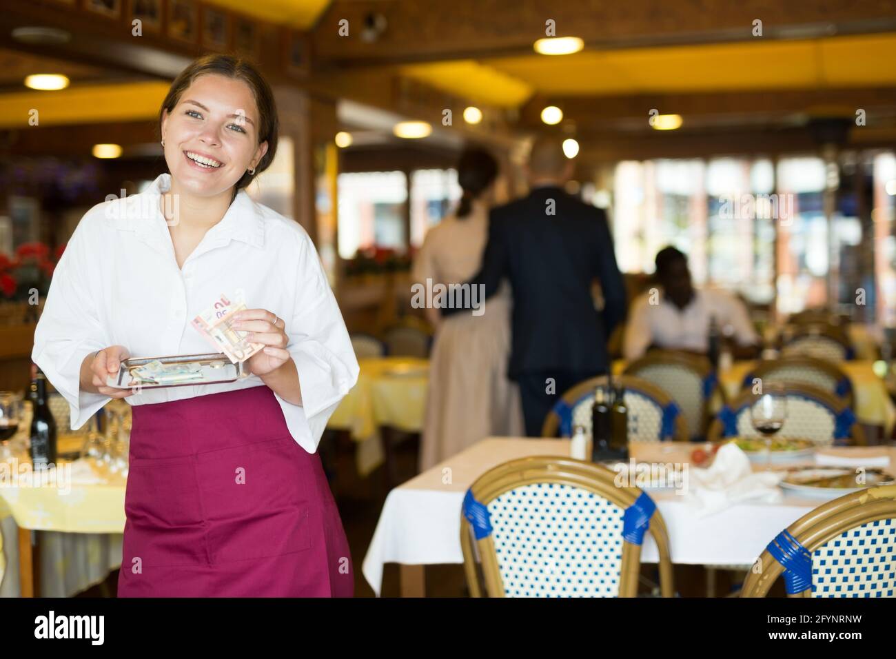 Happy waiter got a good tip from restaurant patrons Stock Photo - Alamy