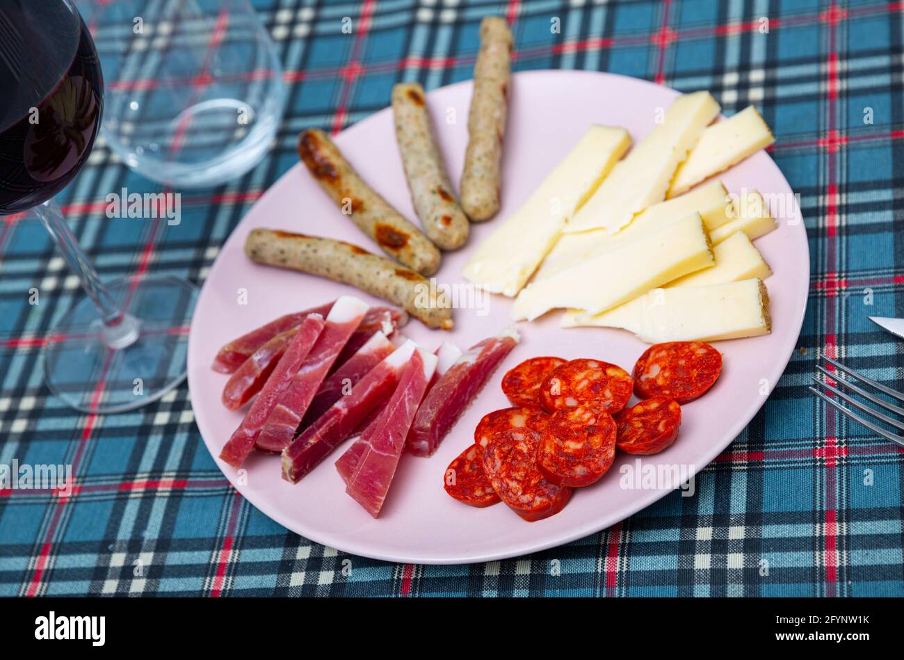 Traditional spanish snack tapas on a plate, selection of ham, salami ...