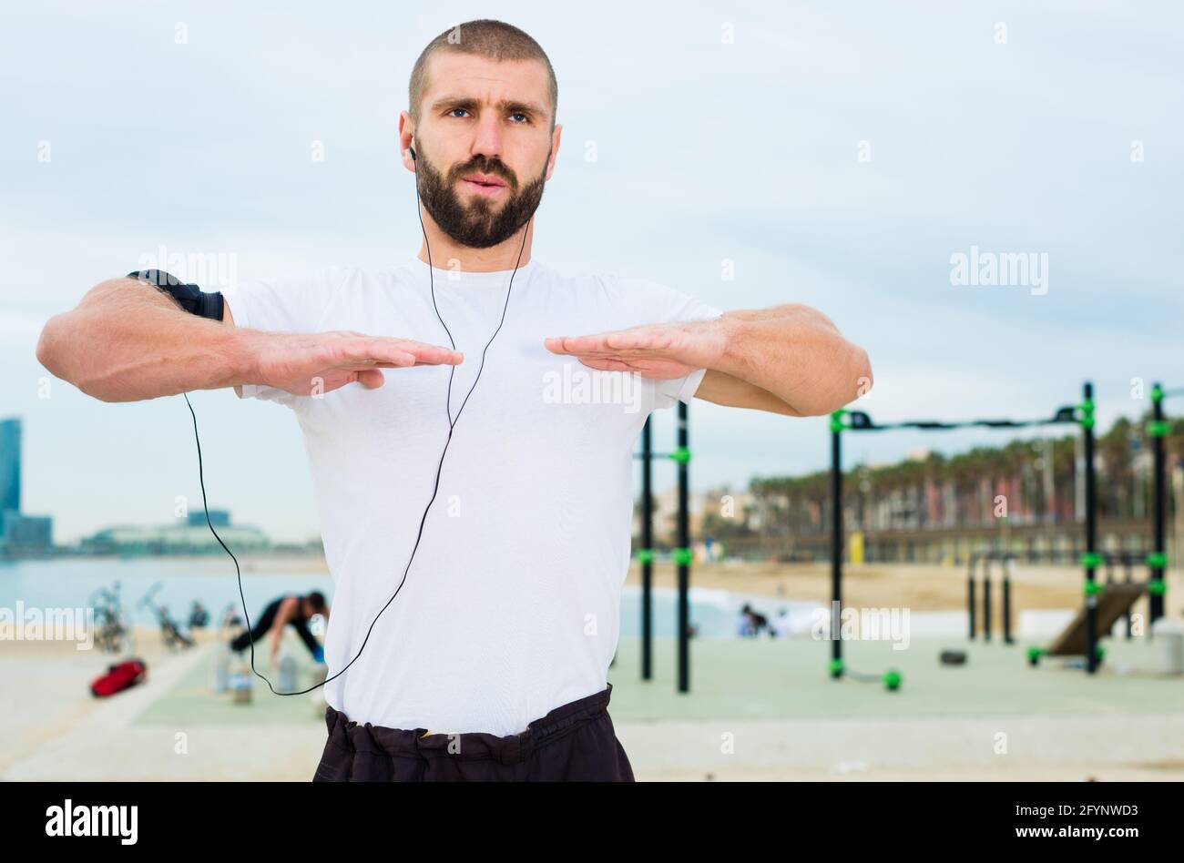 Athletic male performs warm-up exercises before training Stock Photo ...