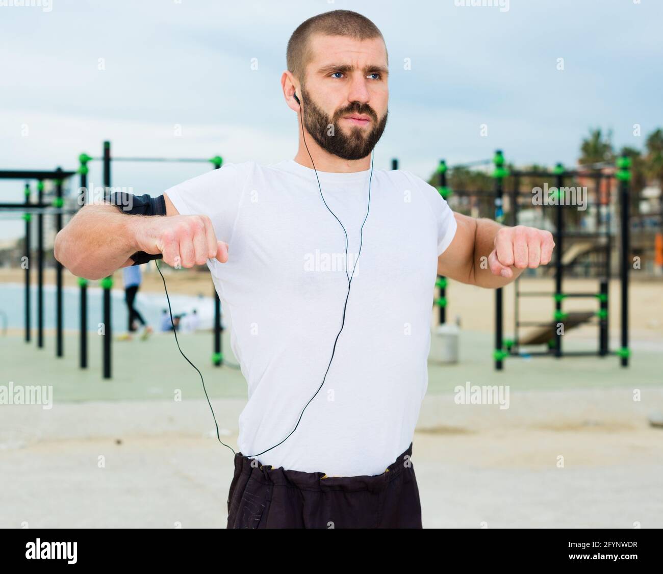 Athletic male performs warm-up exercises before training Stock Photo ...