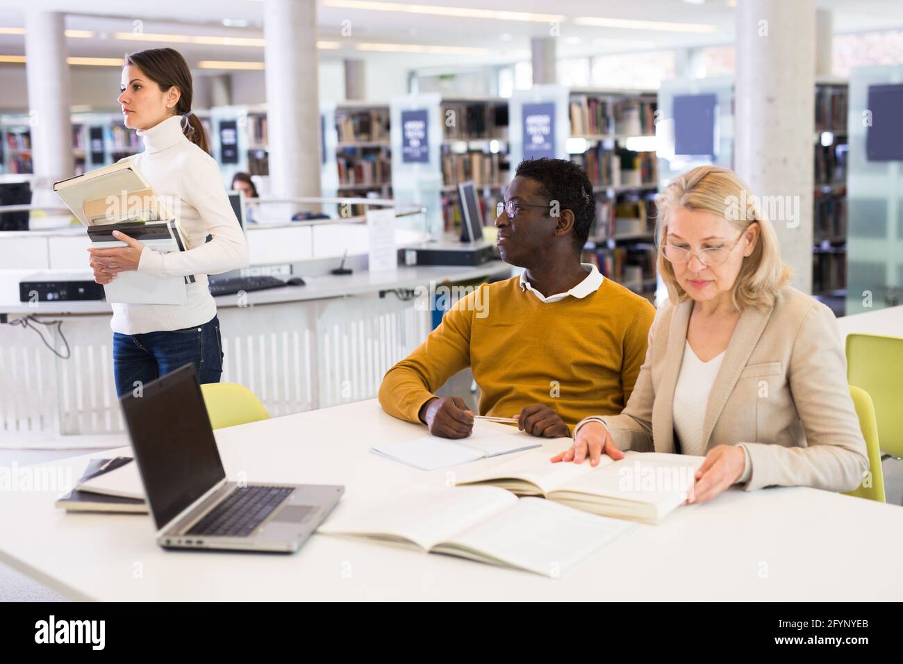 Professor and students communicate in the library Stock Photo - Alamy