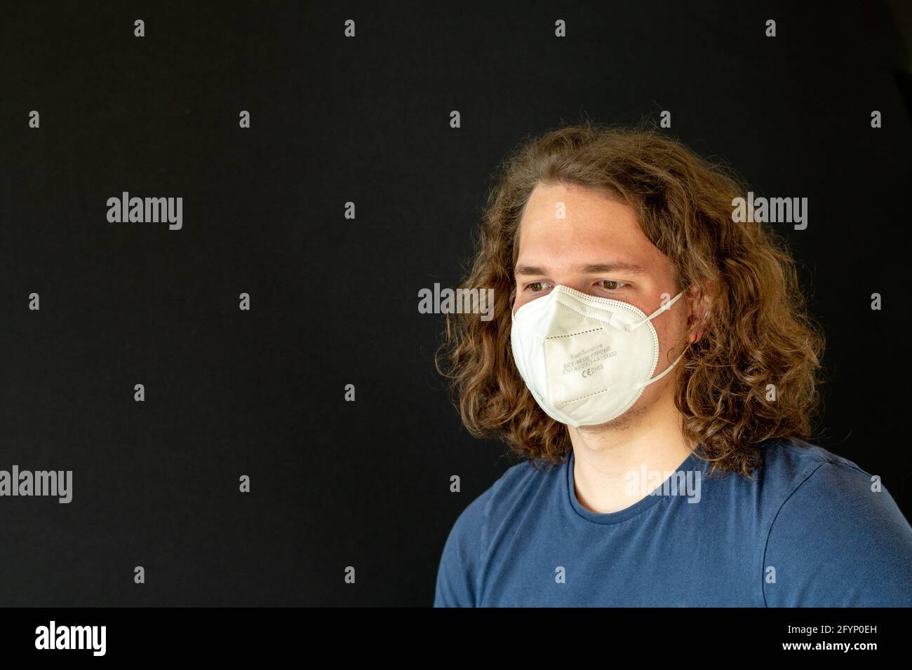 Middle eastern male portrait wearing a white face mask on a black ...