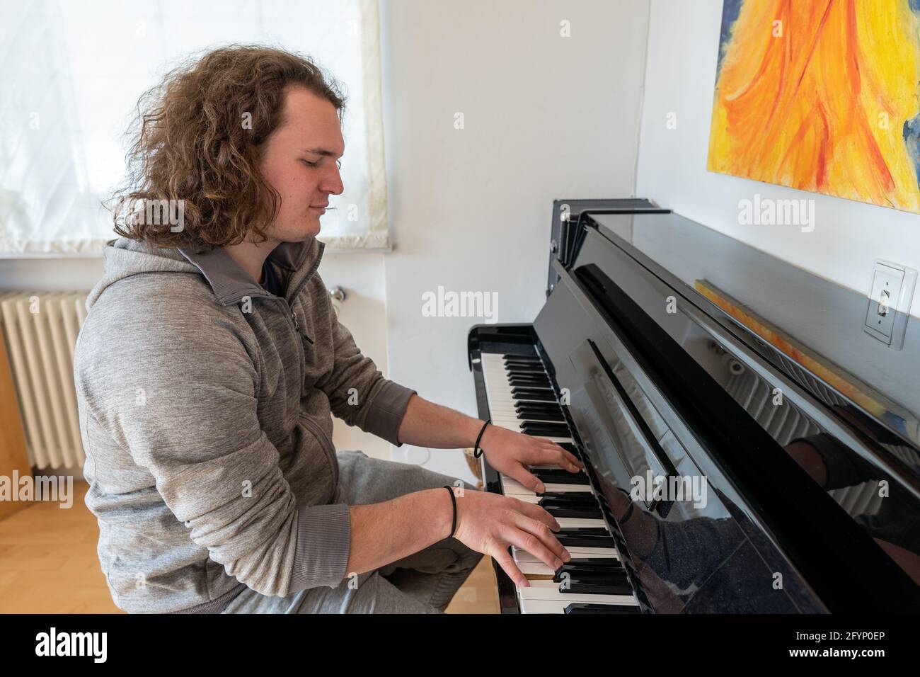 Middle eastern male playing the piano indoors Stock Photo - Alamy