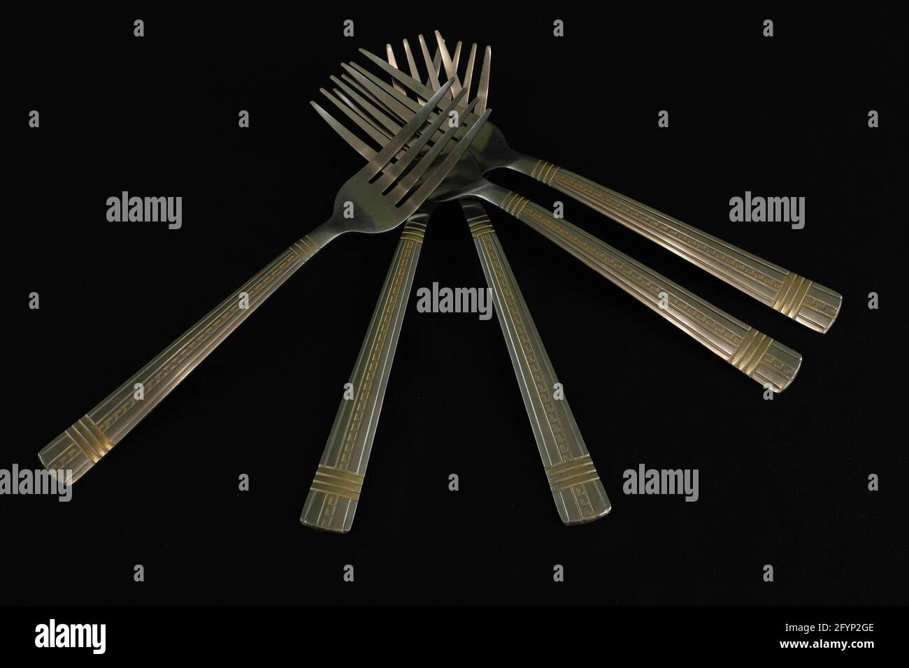 Closeup of five silver forks on a black background Stock Photo - Alamy