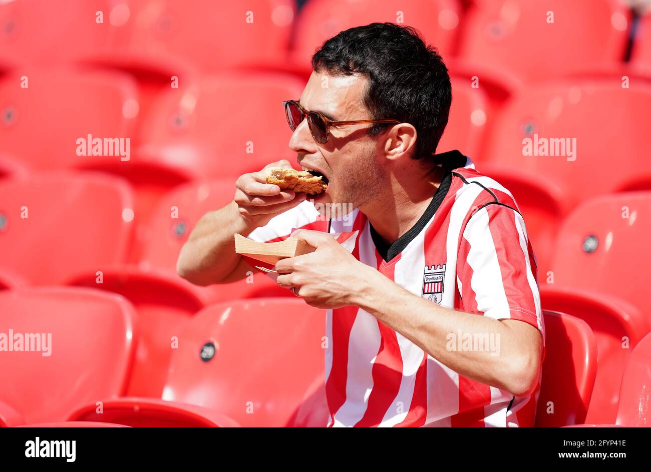 A Brentford fan in the stands eating food during the Sky Bet ...