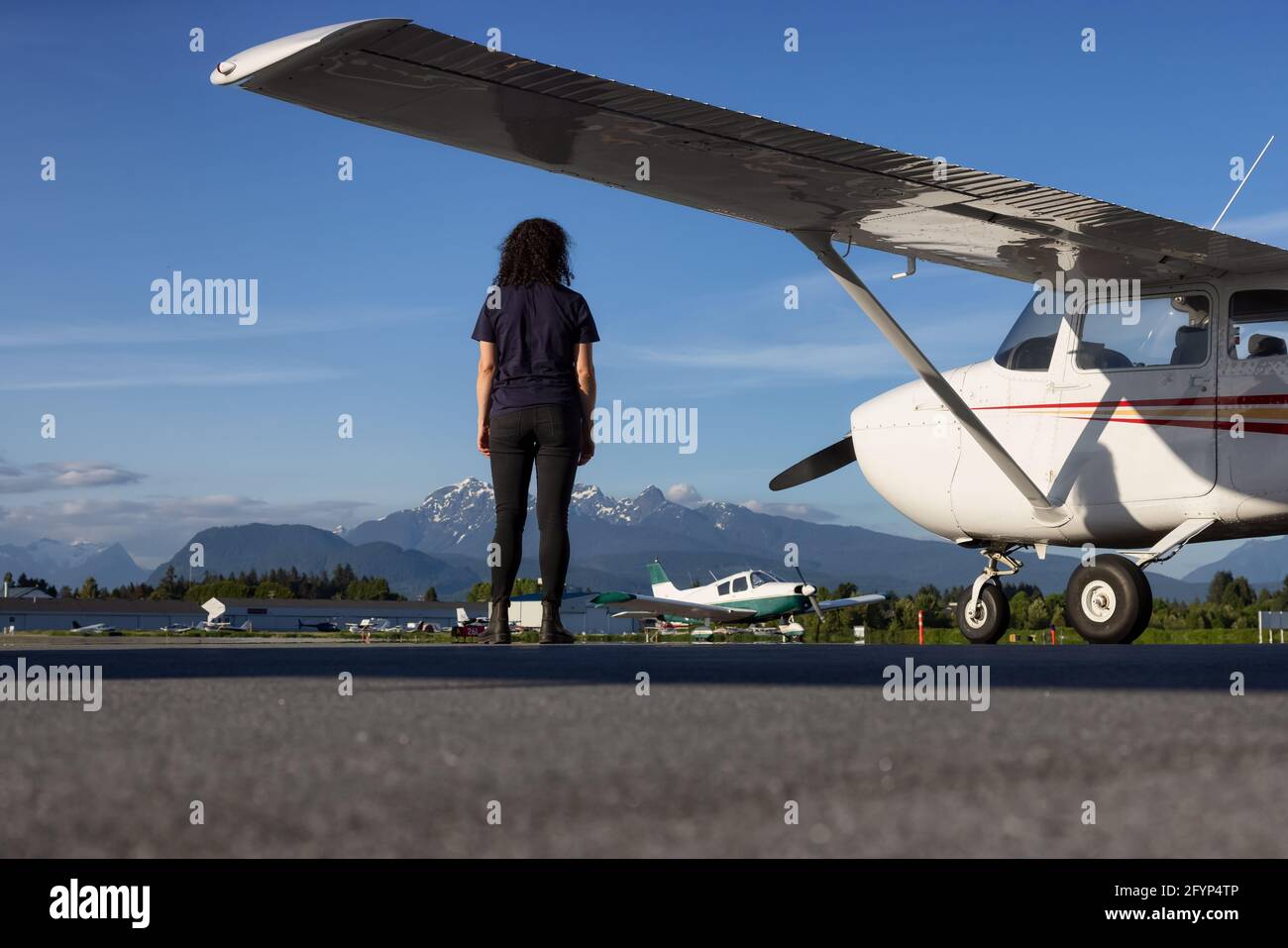 Adventurous woman standing by the Airplane parked at the Airport Stock ...