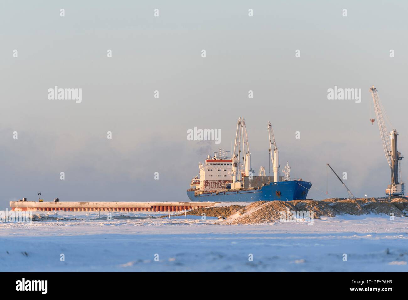 Cargo vessel moored in arctic port. Winter time. Ice navigation ...