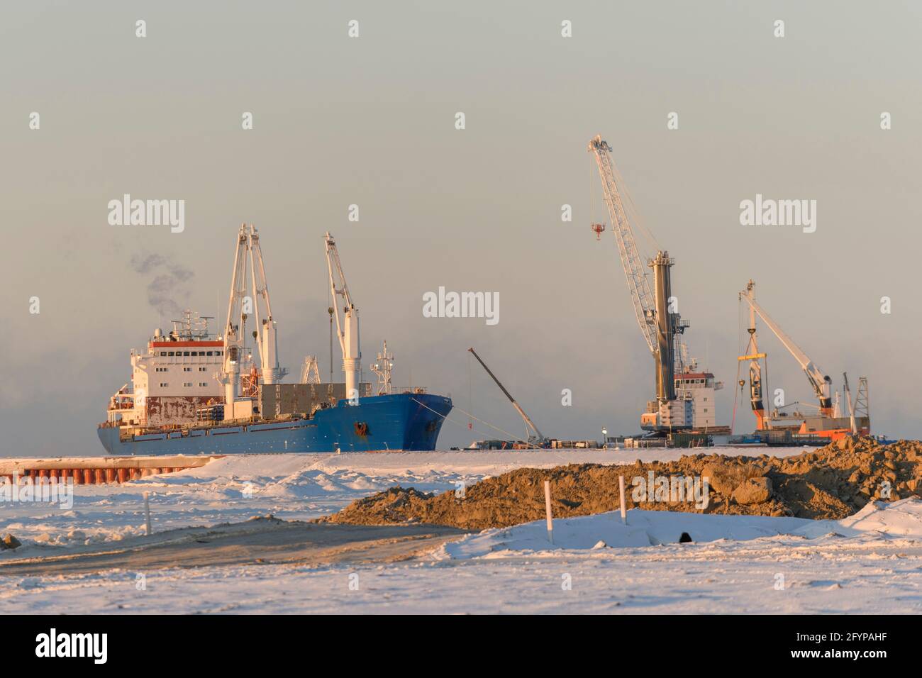 Cargo vessel moored in arctic port. Winter time. Ice navigation ...