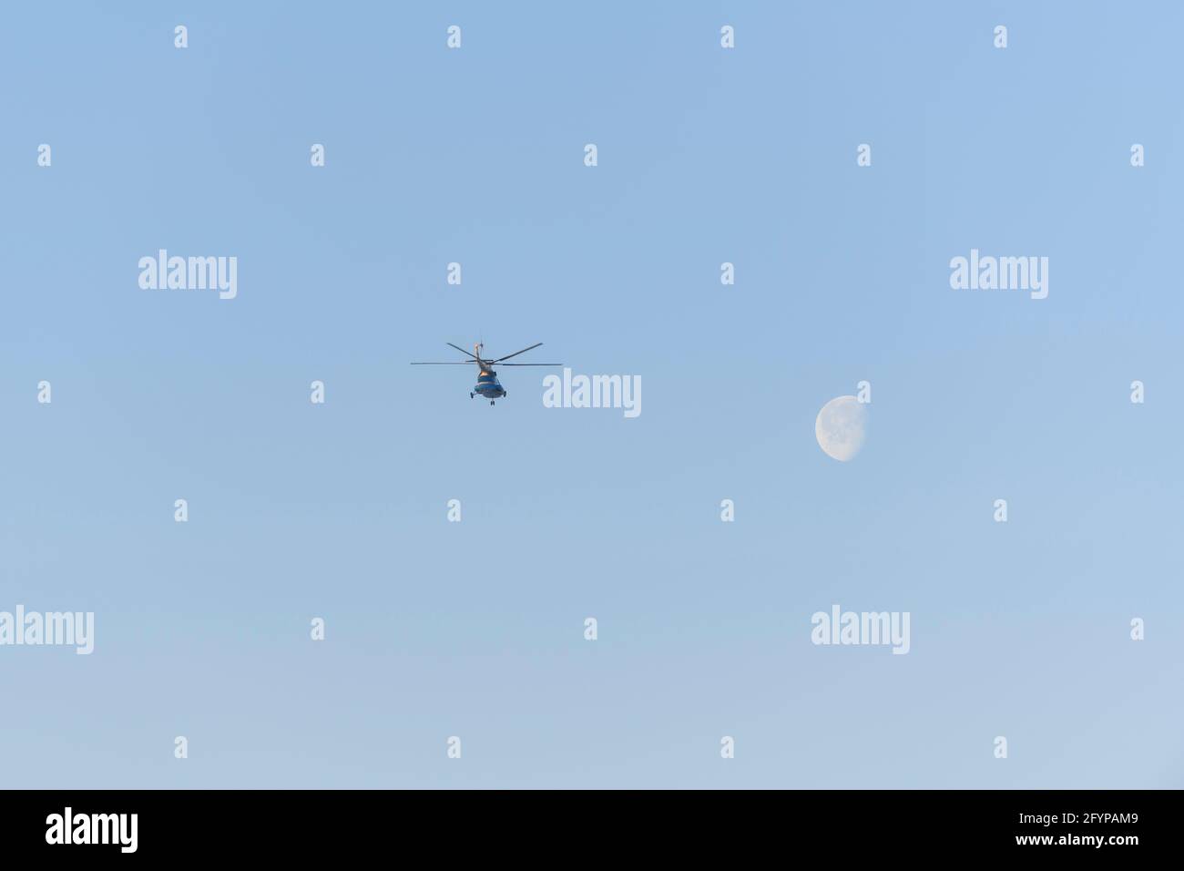 Helicopter flying in the blue sky with moon Stock Photo - Alamy